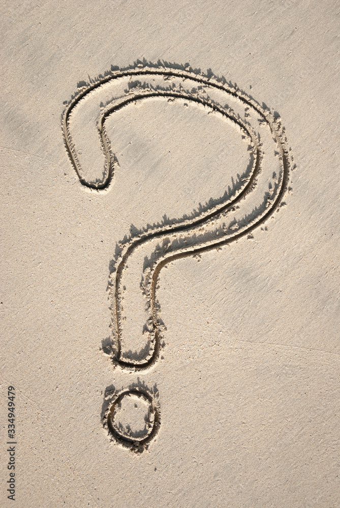 Simple textured question mark drawn by hand on the smooth sand of a ...