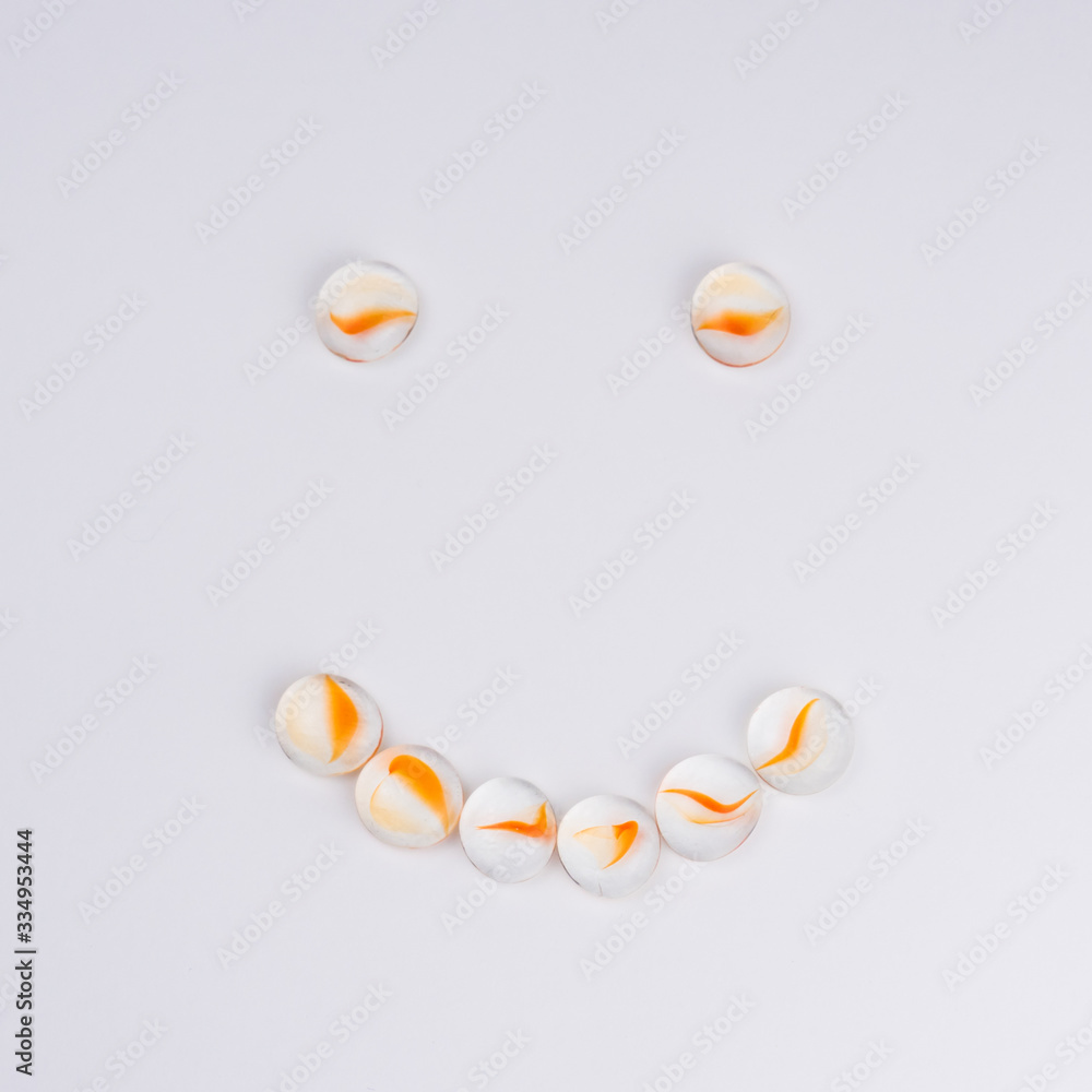 Smile with eyes laid out from a small transparent stone on a white ...