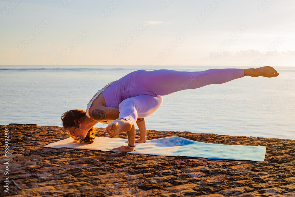 Female practicing variation Mayurasana, Peacock pose. Hand-balancing ...