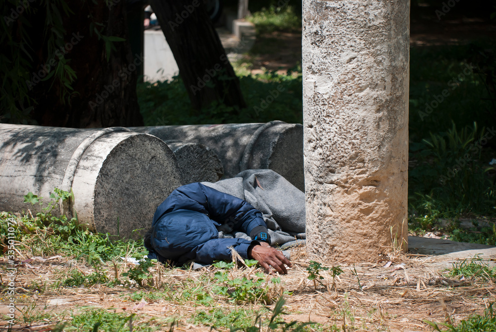 Athens, Greece, April 2020: Homeless man laying sleeping amongst ...