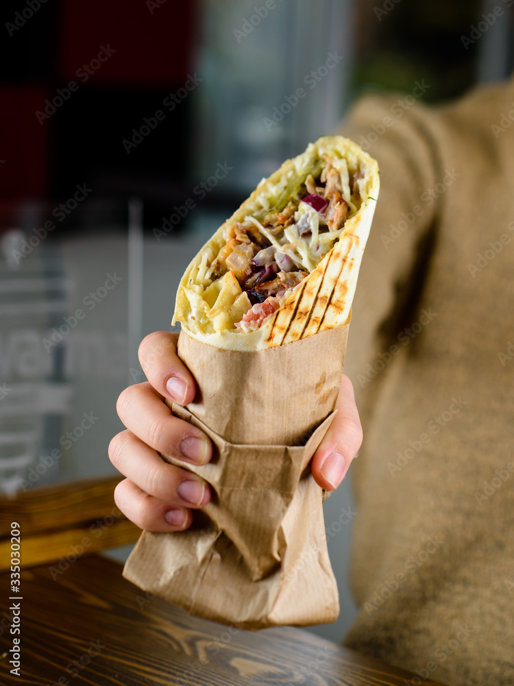 shawarma in the hands of a woman Stock Photo | Adobe Stock