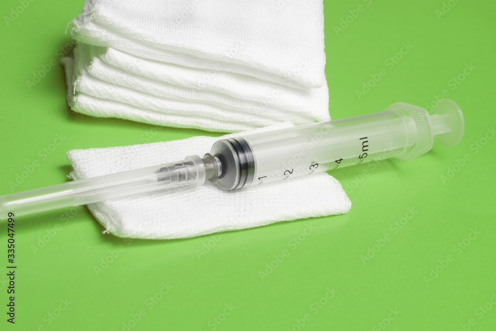 set for injection, syringe and sterile wipes on a green background ...