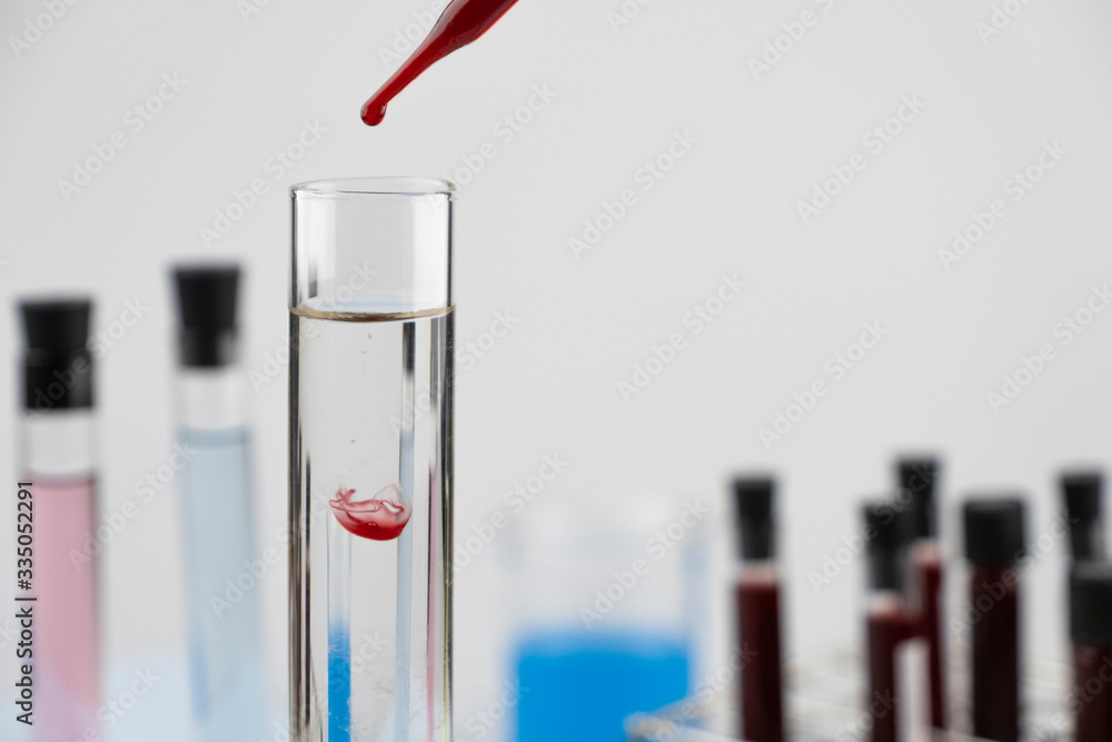 Clear science liquid in test tube with blood sample from pipette ...