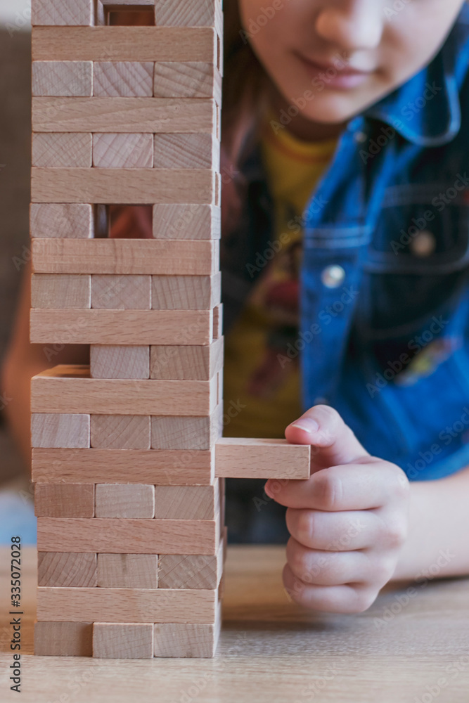 Children at home play the game of Jenga and pull out blocks from the ...