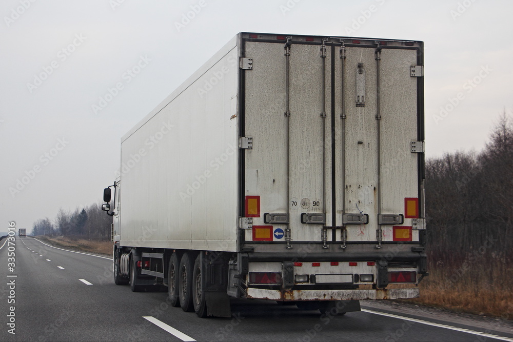 Foto de White semi truck van move on suburban asphalted highway road at ...