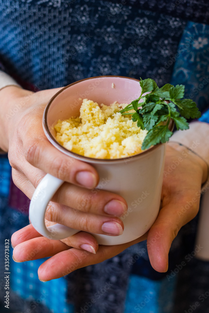 Cooked couscous durum wheat grain porridge in cup. Crushed semolina ...