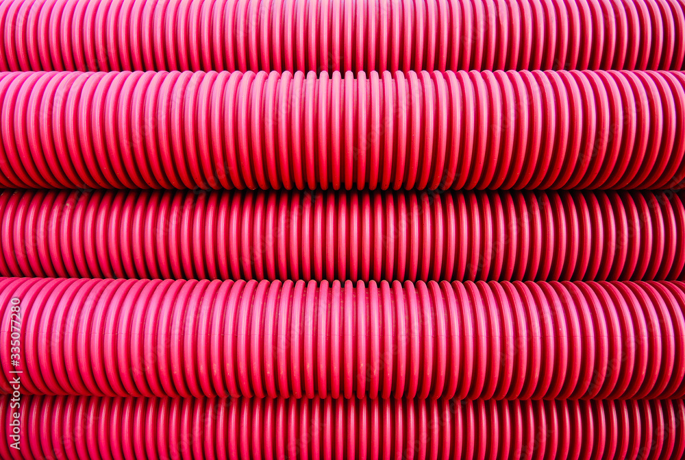 Red plastic corrugated tubing, synthetic pipes used in construction, an ...