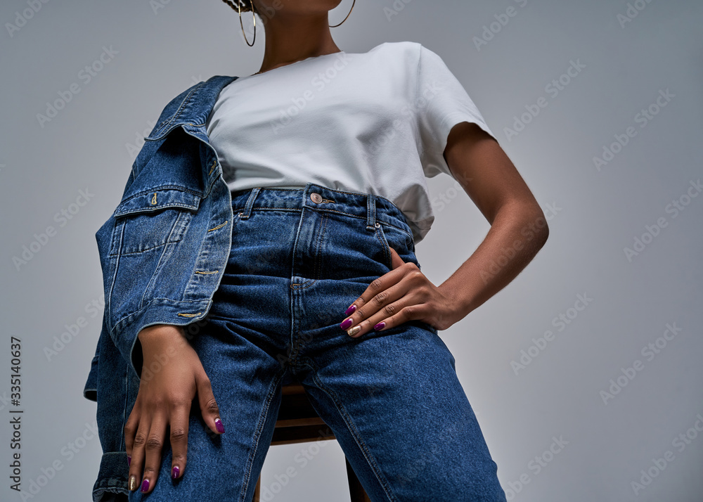 Girl in white t-shirt in jeans with denim jacket posing on camera holds ...