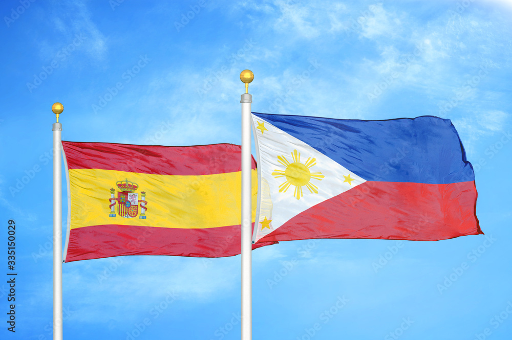Spain and Philippines two flags on flagpoles and blue cloudy sky Stock ...