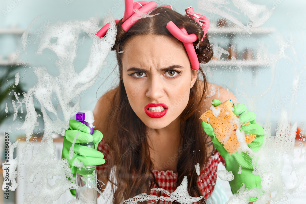 Funny angry housewife cleaning kitchen window Stock Photo | Adobe Stock