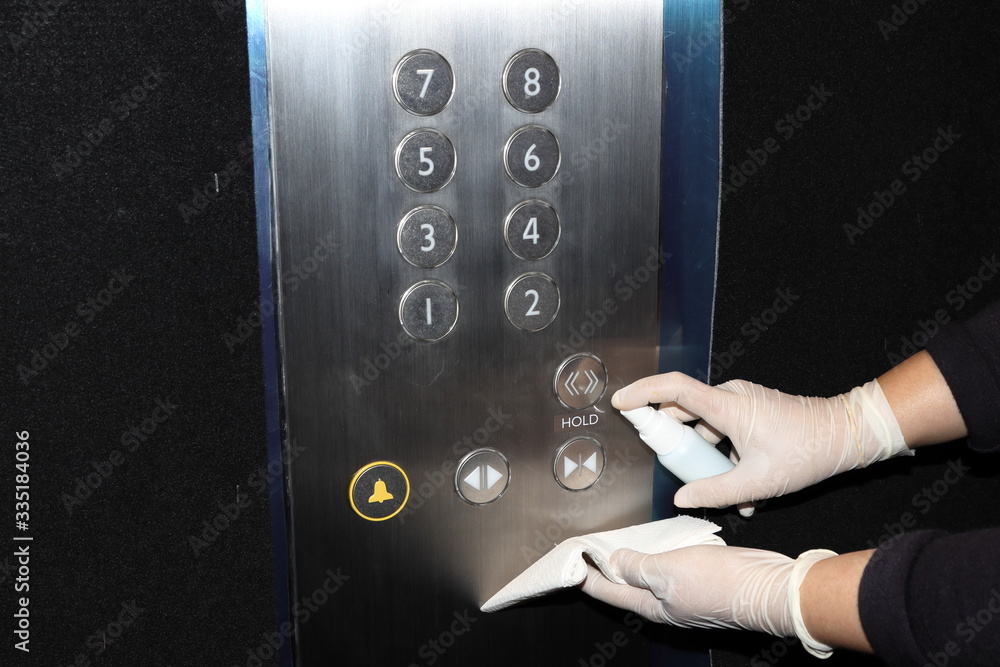 Cleaning staff cleaned the switch button in elevator with alcohol spray ...