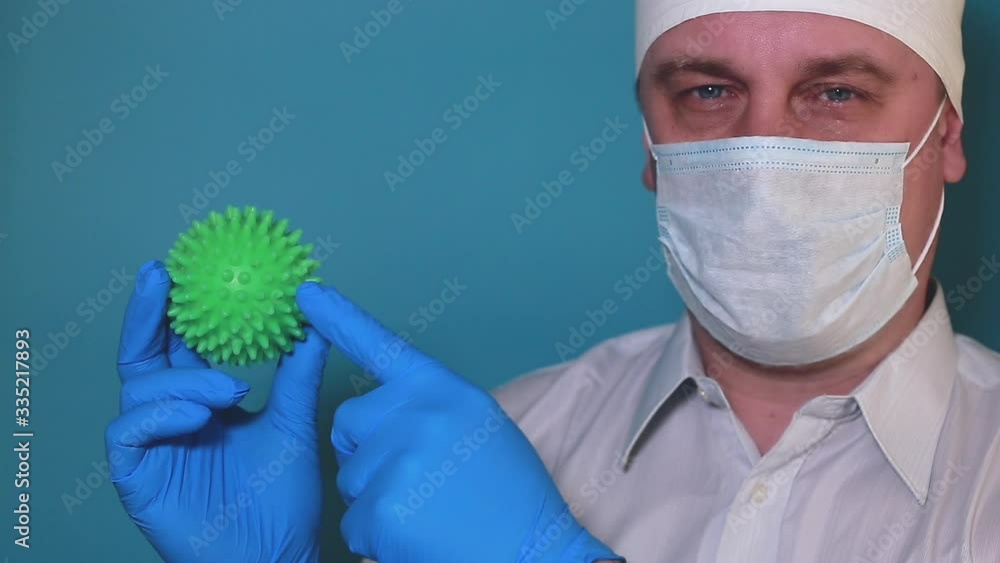 A European male doctor or surgeon, wearing a mask and medical uniform ...