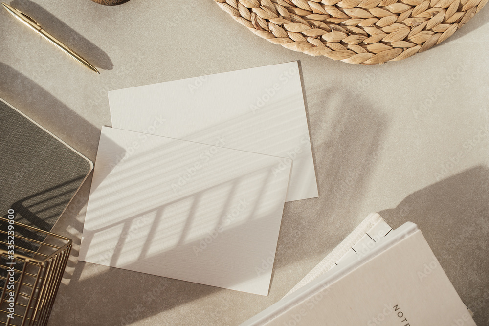 Flatlay blank paper sheet, notebooks, clips in wooden bowl, straw stand ...