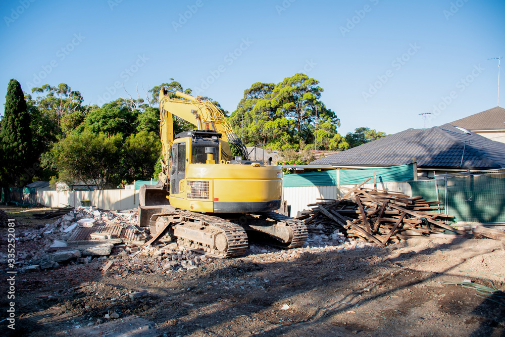 Excavator working on demolition of the resedential building. Debris on ...