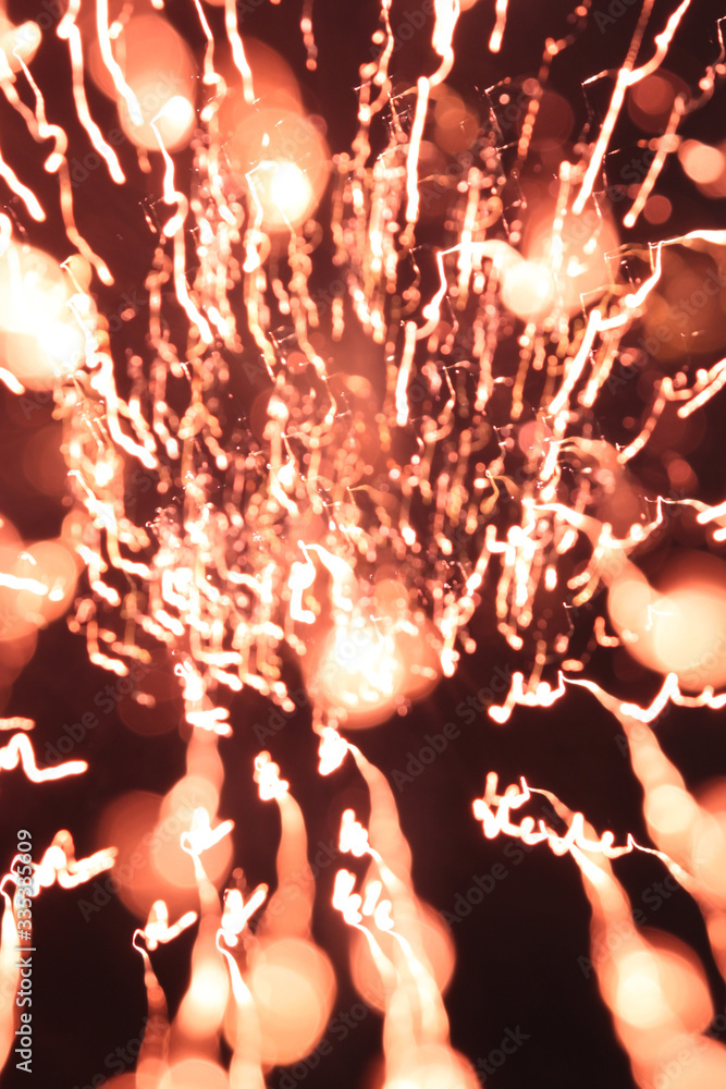 fizzling and glowing fireworks streaming light from black sky ...