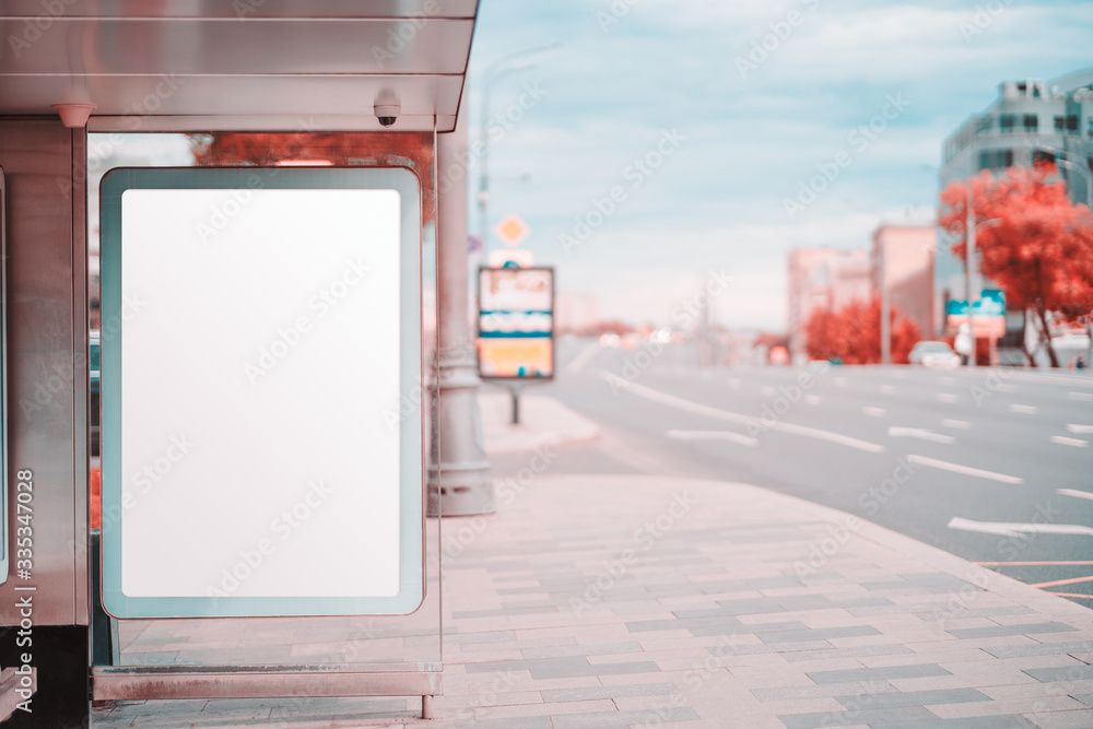 A city bus stop with an empty ad banner mock-up; template of ...