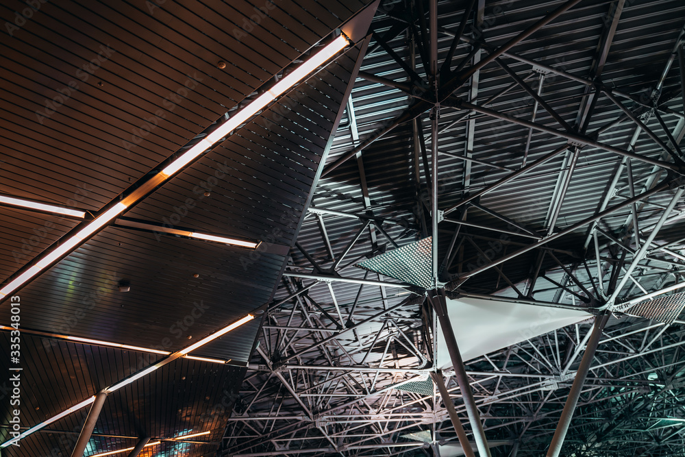 Indoor wide-angle bottom view of modern roof construction of an airport ...