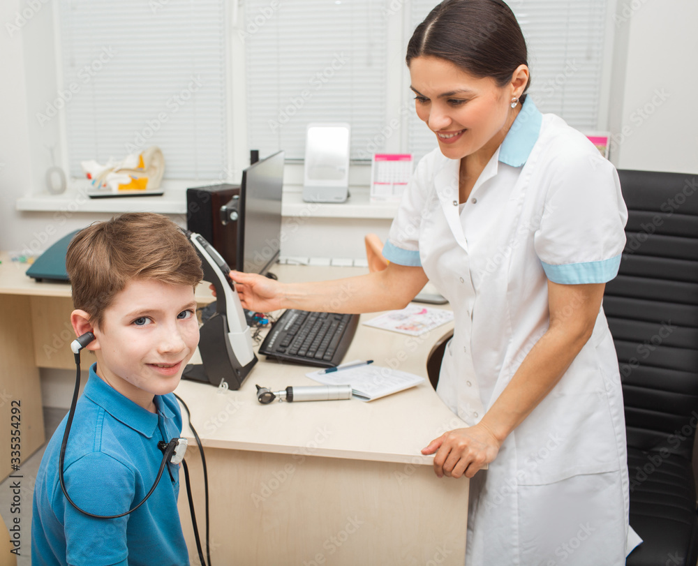 Female otolaryngologist doing a hearing test in a boy. Tympanometry ...