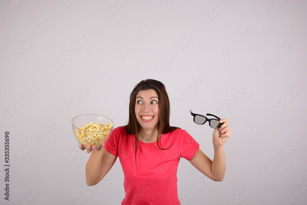 woman with popcorn in cinema on a light background emotions smile ...