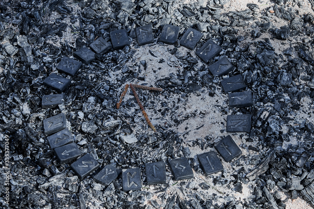 Norse rune Teihwaz on ashes backgorund inside the circle of 24 Norse ...
