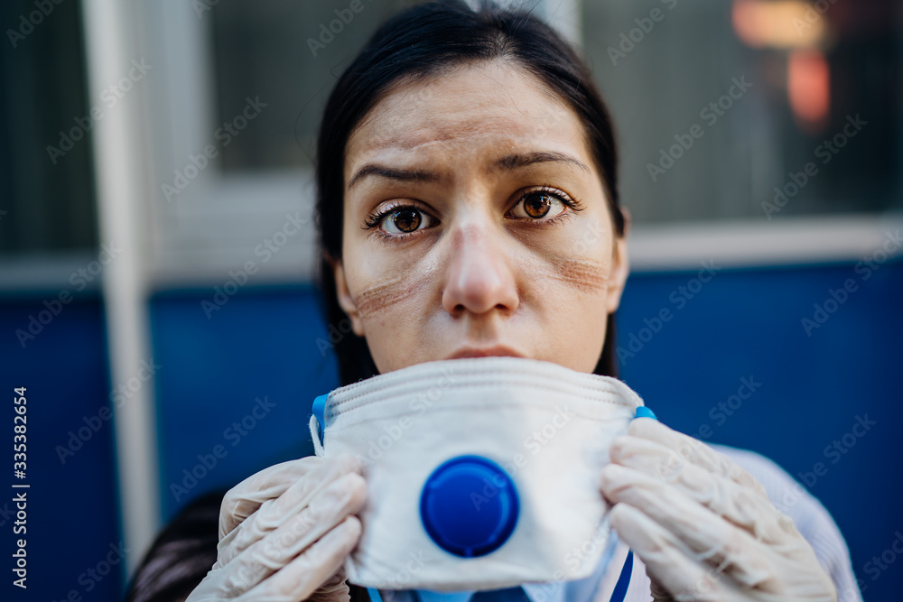 Exhausted doctor / nurse taking of coronavirus protective gear N95 mask ...
