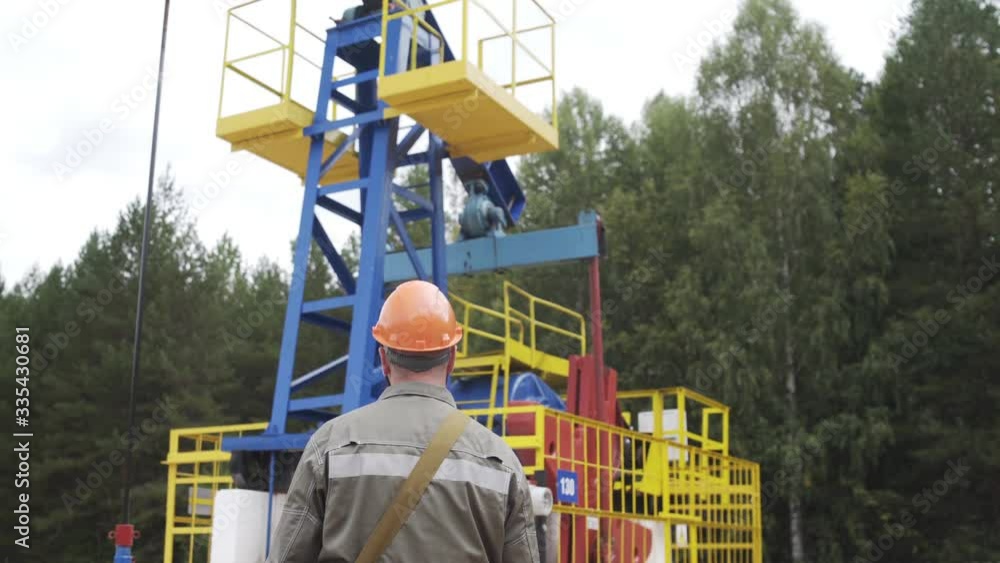 Oil field technical worker overseeing site of crude oil production ...