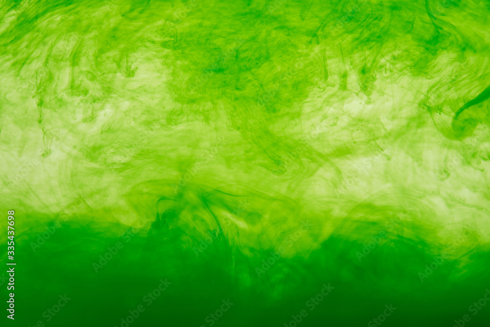streaks of green paint dissolve in water. Smoke, a witch's potion, the ...