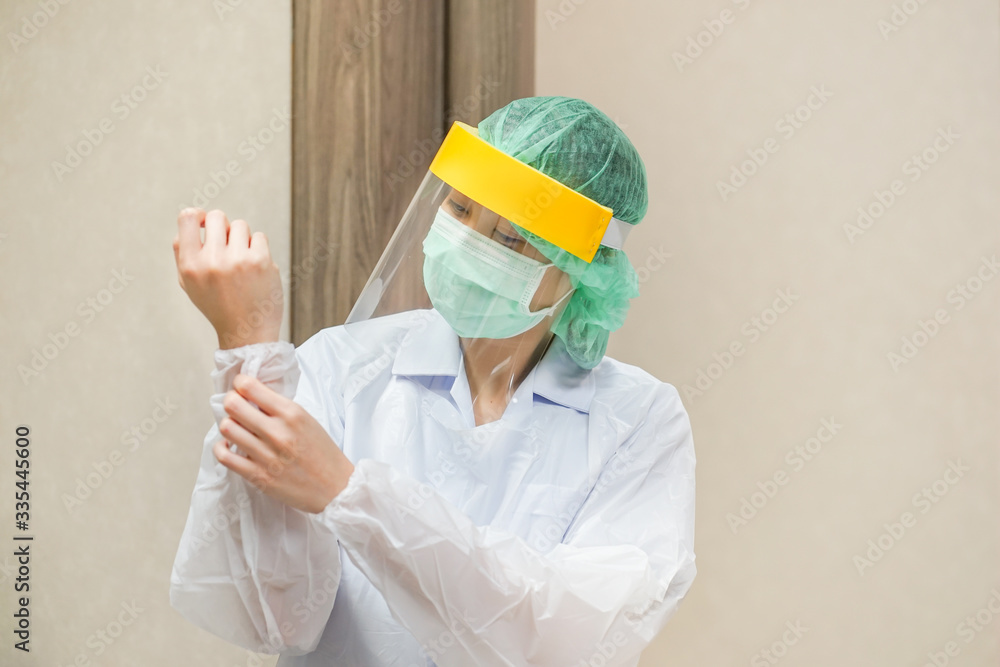 Front-line healthcare workers prepare wearing Personal Protective ...
