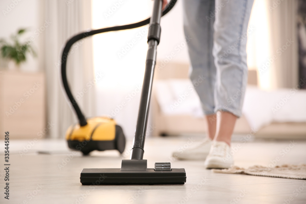 Young woman using vacuum cleaner at home, closeup Stock Photo | Adobe Stock