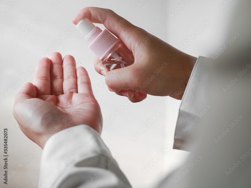 Hand of lady that applying alcohol spray hand sanitiser to hand to ...