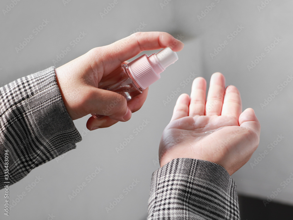 Hand of lady that applying alcohol spray hand sanitiser to hand to ...