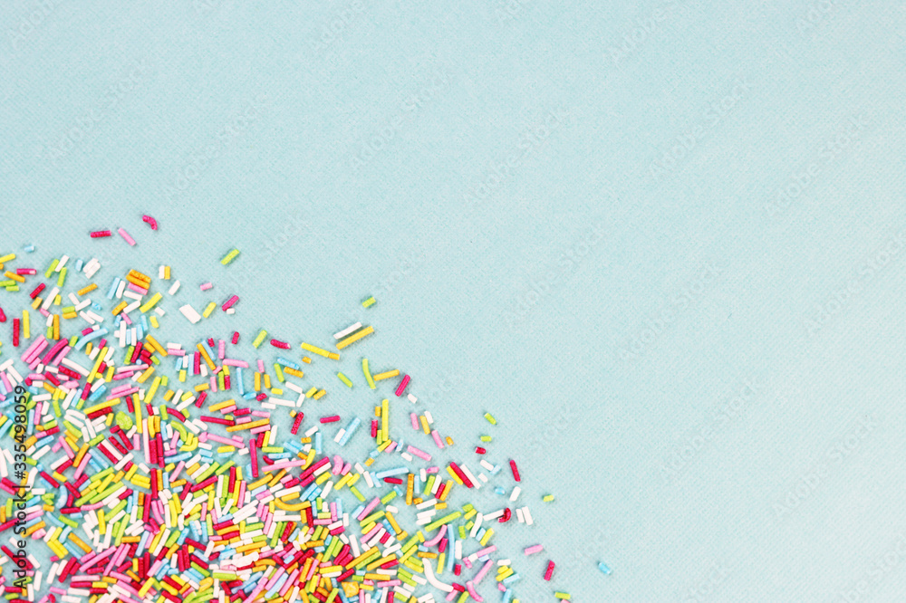 culinary pastry rainbow sprinkles are scattered on a blue background ...