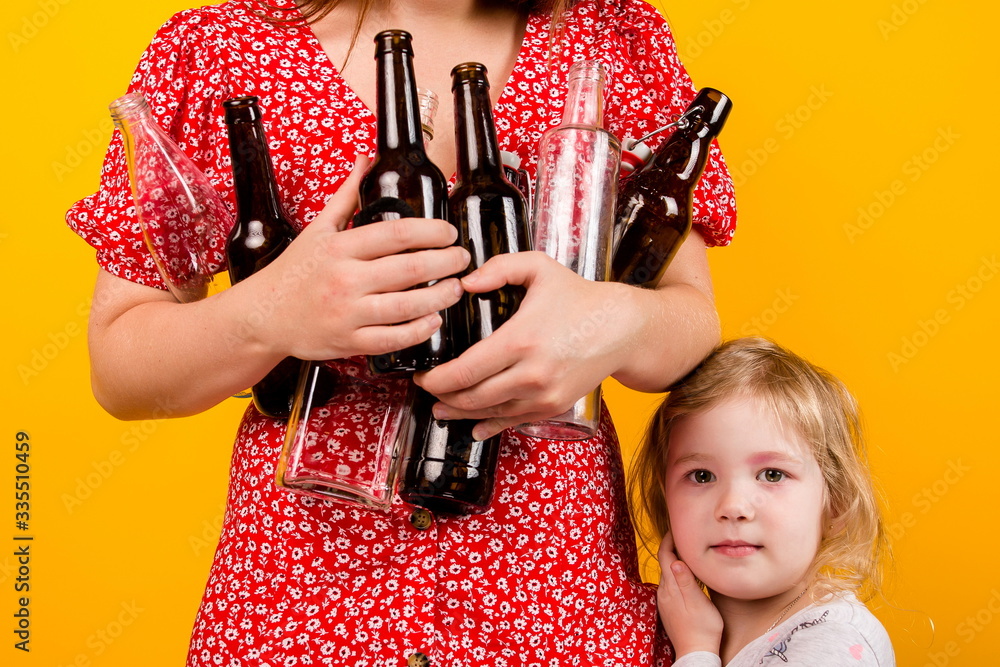 Foto de Drunk mother holding many bottles of alcohol, standing next to ...