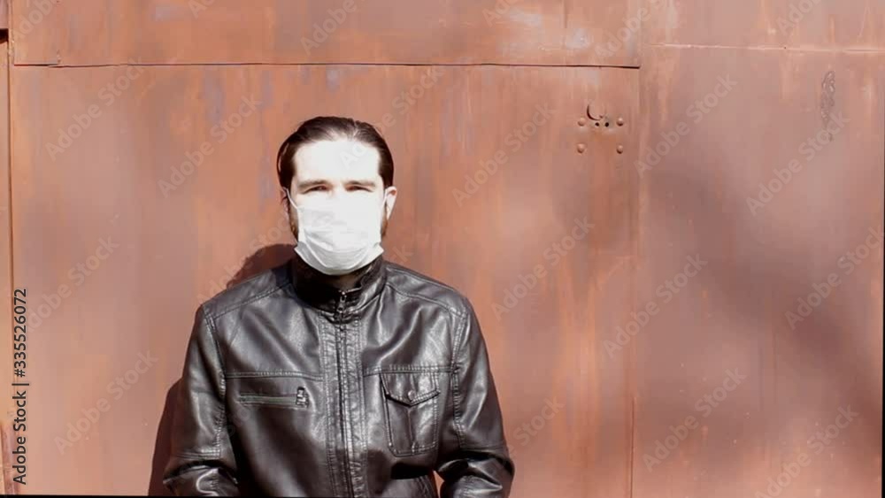 man puts on and removes a disposable mask to protect against the ...