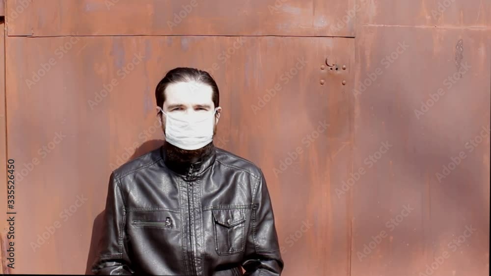 man puts on and removes a disposable mask to protect against the ...