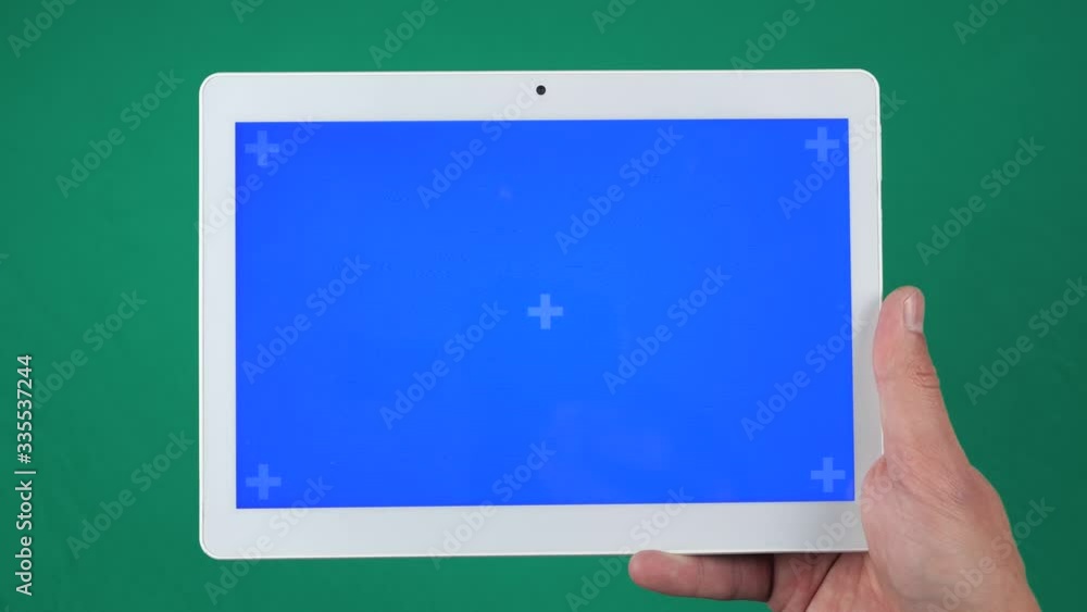Horizontal tablet in the hand closeup isolated at green background ...