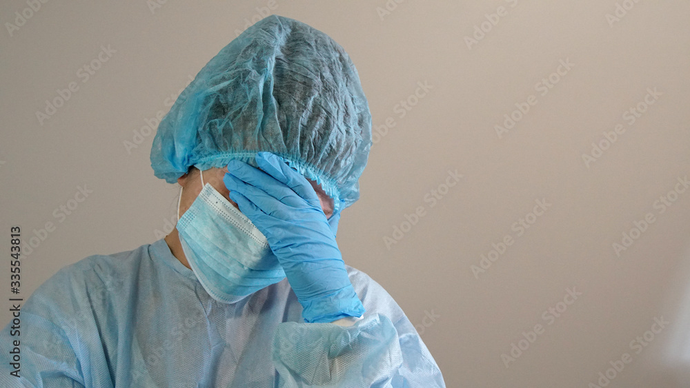 facepalm. nurse in a sterile mask, a medical gown and a cap. close-up ...