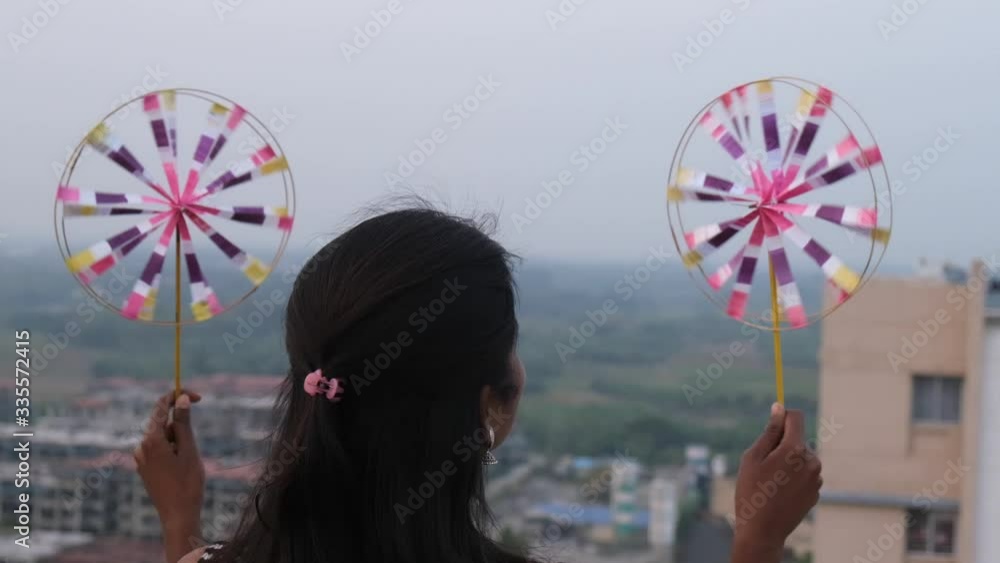 A dark skinned young Indian/African lady in western wear playing with ...