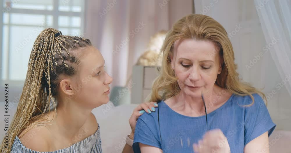 Adult daughter consoling her upset mom in depression. Grown-up child ...