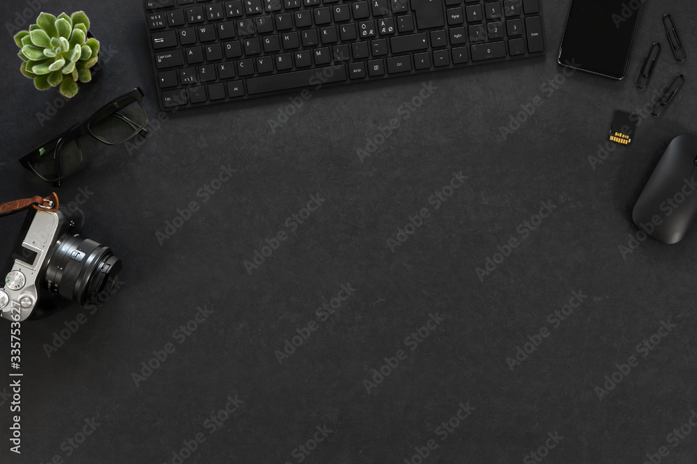 Top view of black concrete office desk with computer, camera and ...