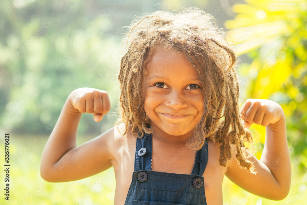 Mowgli indian boy with dreadlocks hair showing muscle arms in tropics ...