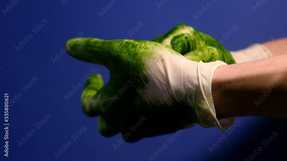Man in rubber gloves show how to wash hands properly. Use color paint ...