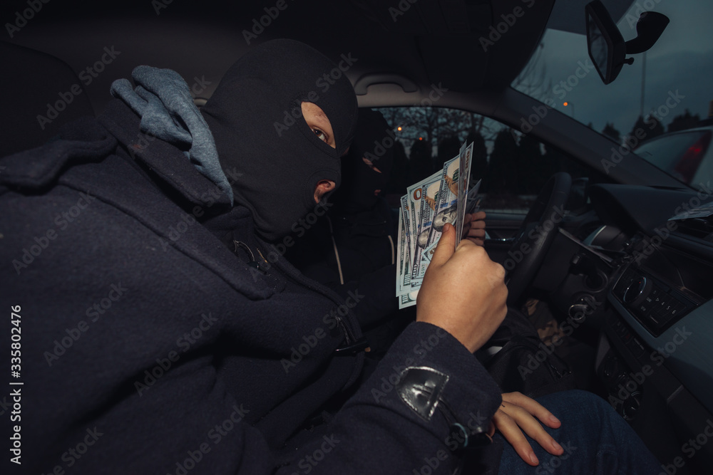 Poster Two masked robbers counting the money they made while sitting in ...