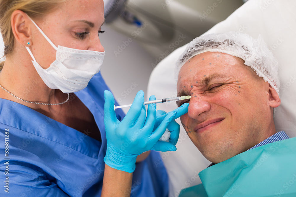 Female doctor is doing injection to patient in skin of face Stock Photo ...