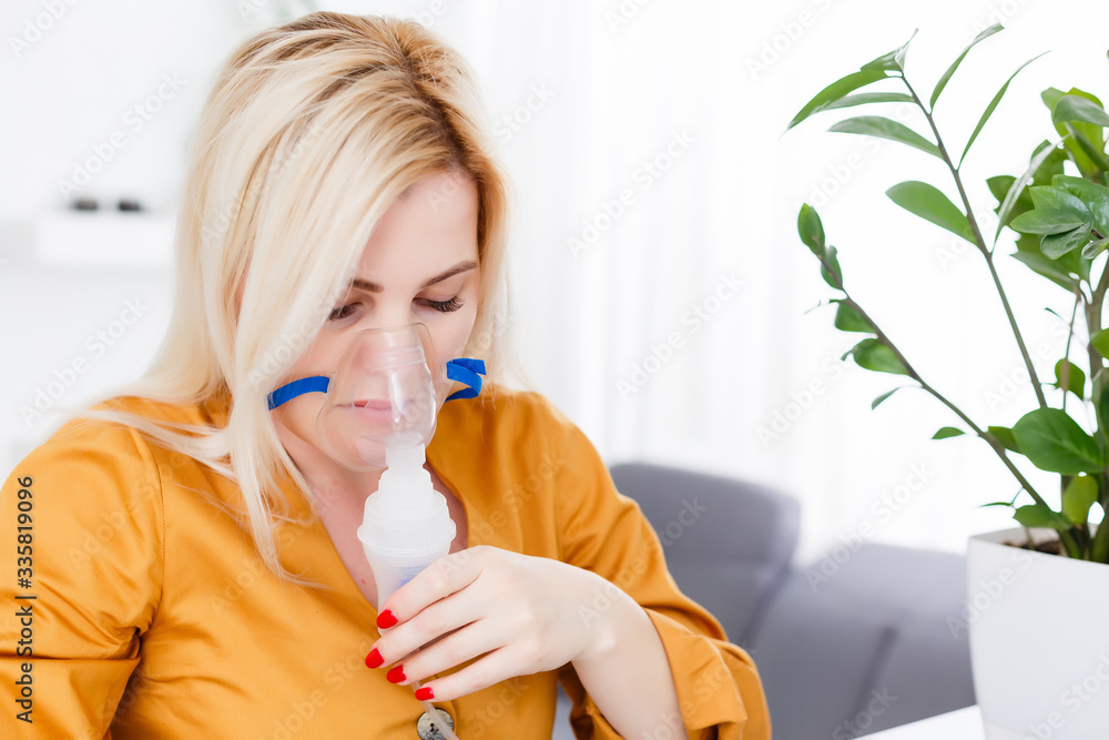 Sick beautiful female holds nasal mask with respiratory problem in ...