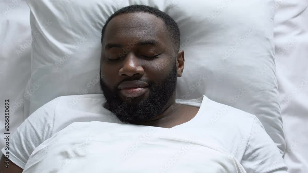 Handsome african american man sleeping in his cozy white bed, healthy ...