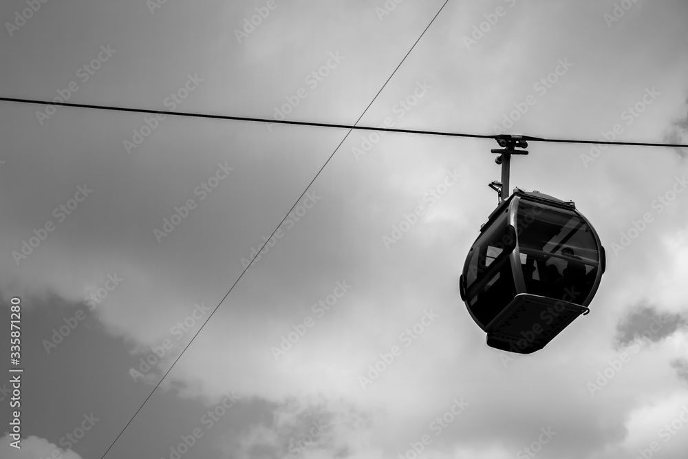 Detail of a cable car moving from right to left in the background sky ...