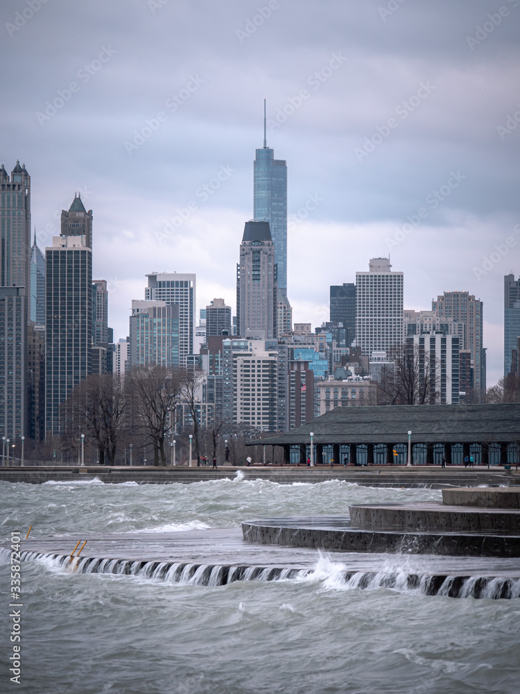 Chicago skyline view with waves crashing into the tiered shoreline and ...