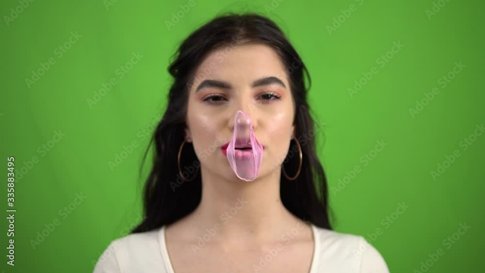 Stockvideon Sexy Beauty Girl Chewing Gum Blowing Bubbles Gum On Green