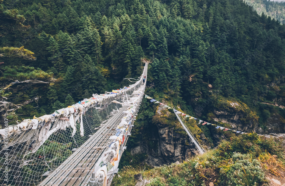 Suspension Bridge decorated with multicolored Tibetan Prayer flags ...